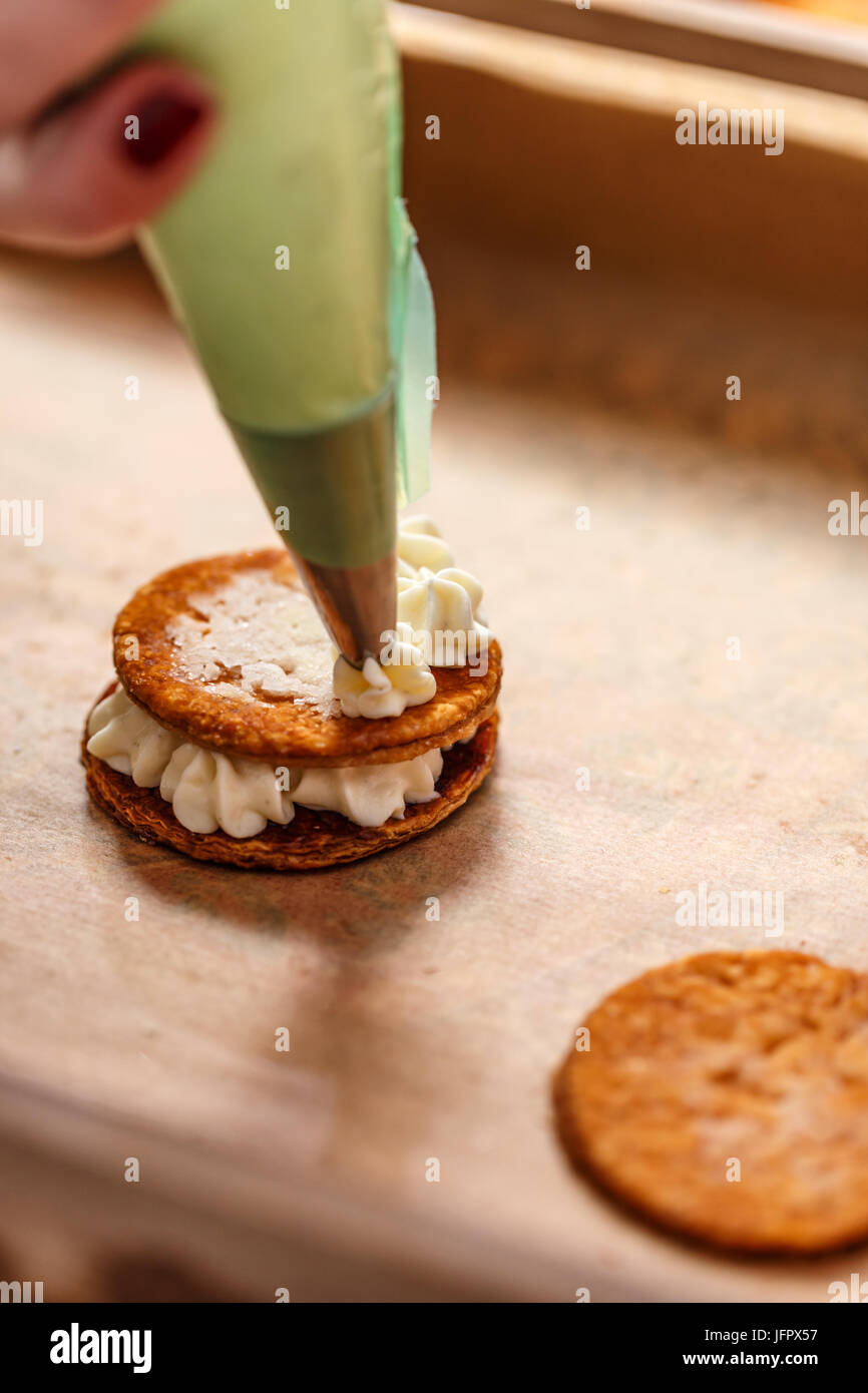 Woman hand decorating mille-feuille cake with pastry cream Stock Photo ...