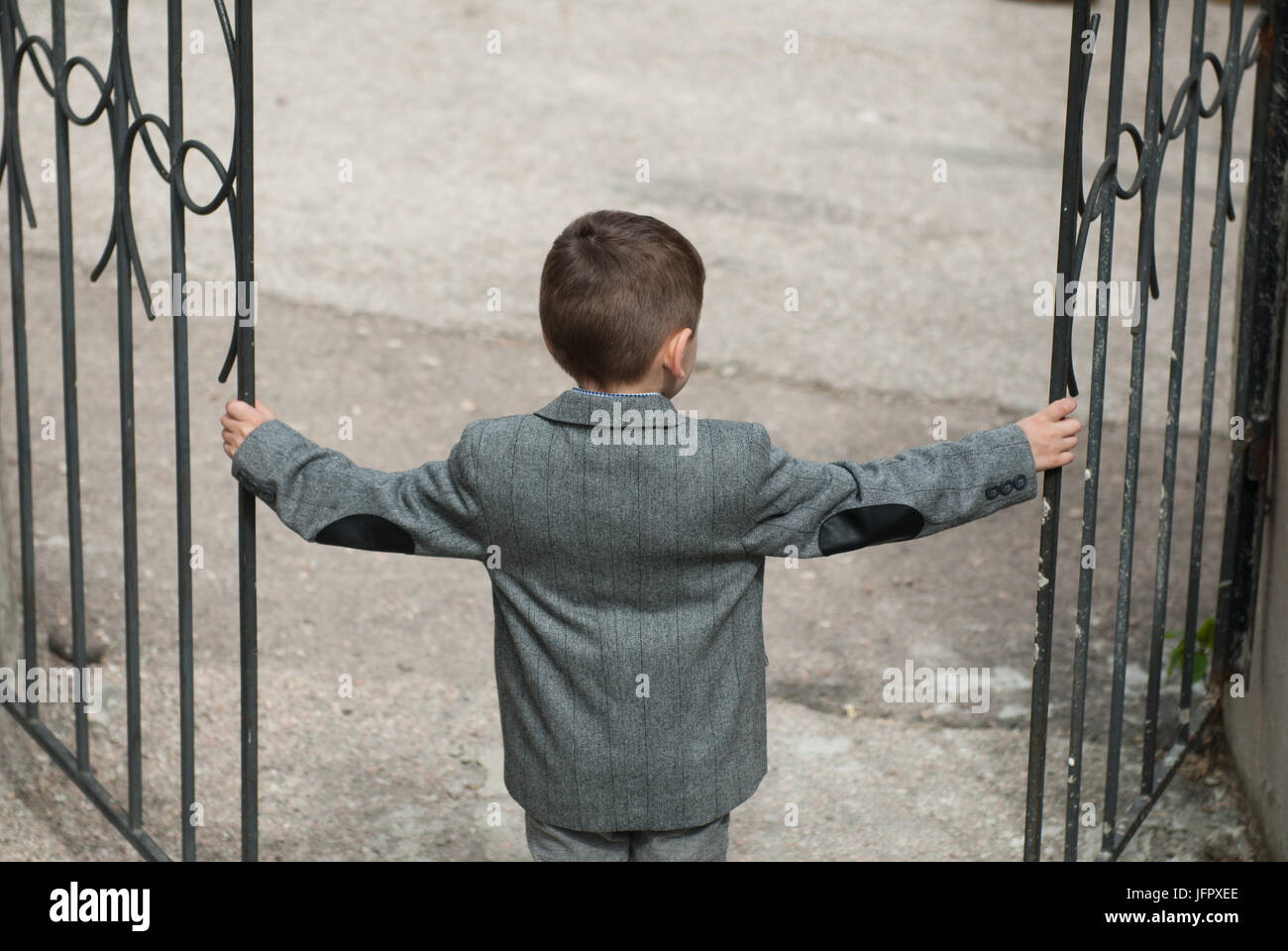 small kid opens a wrought-iron gate Stock Photo - Alamy