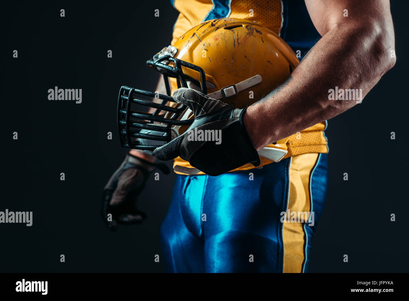 Muscular player with american football helmet in hand. Contact sport ...