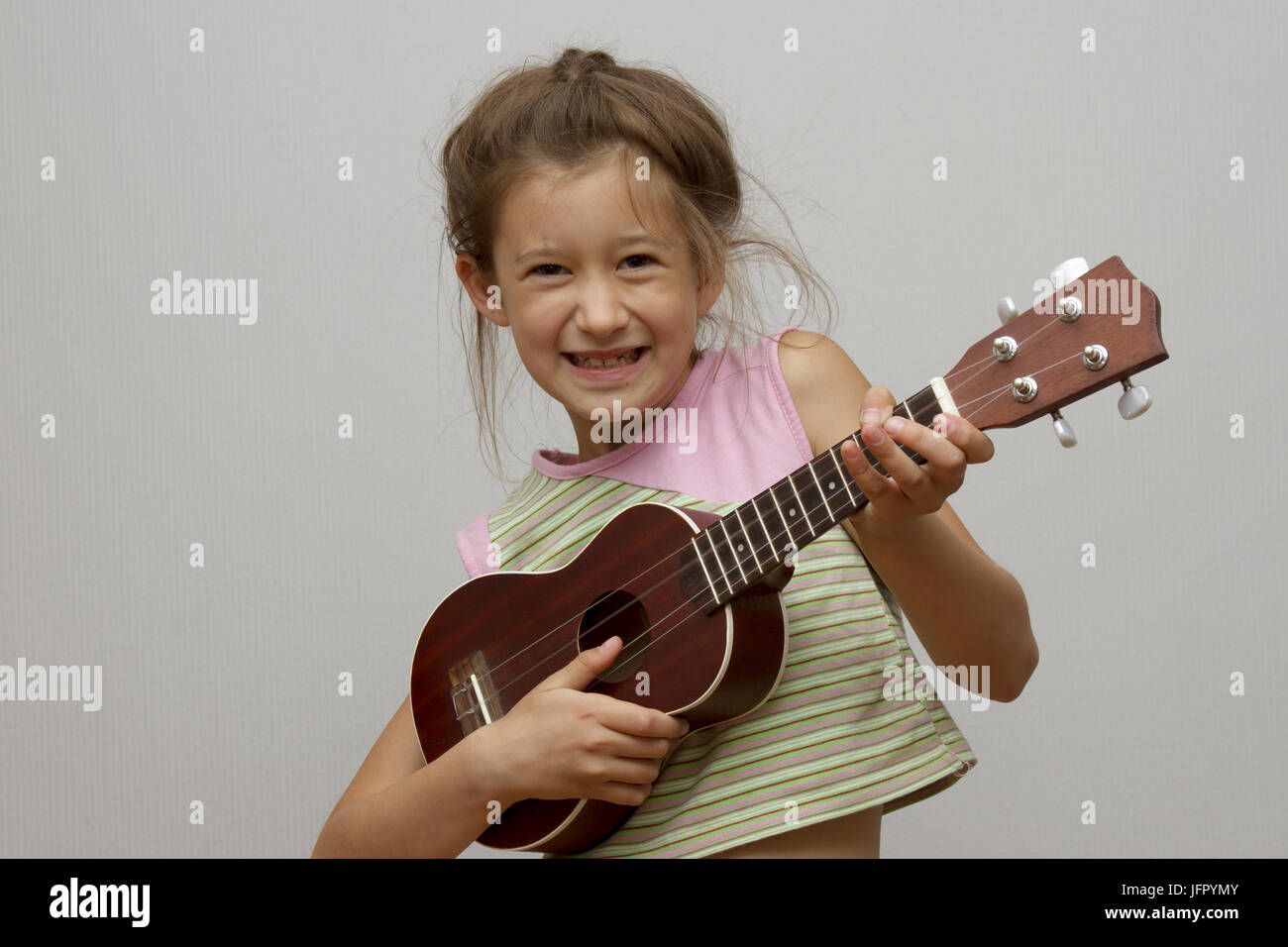 Beautiful girl playing ukulele Stock Photo - Alamy