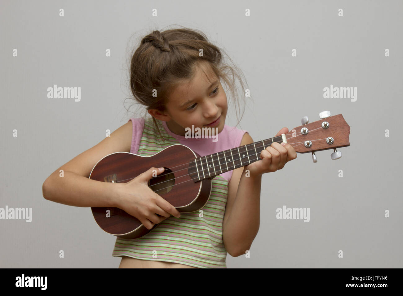 Beautiful girl playing ukulele Stock Photo - Alamy