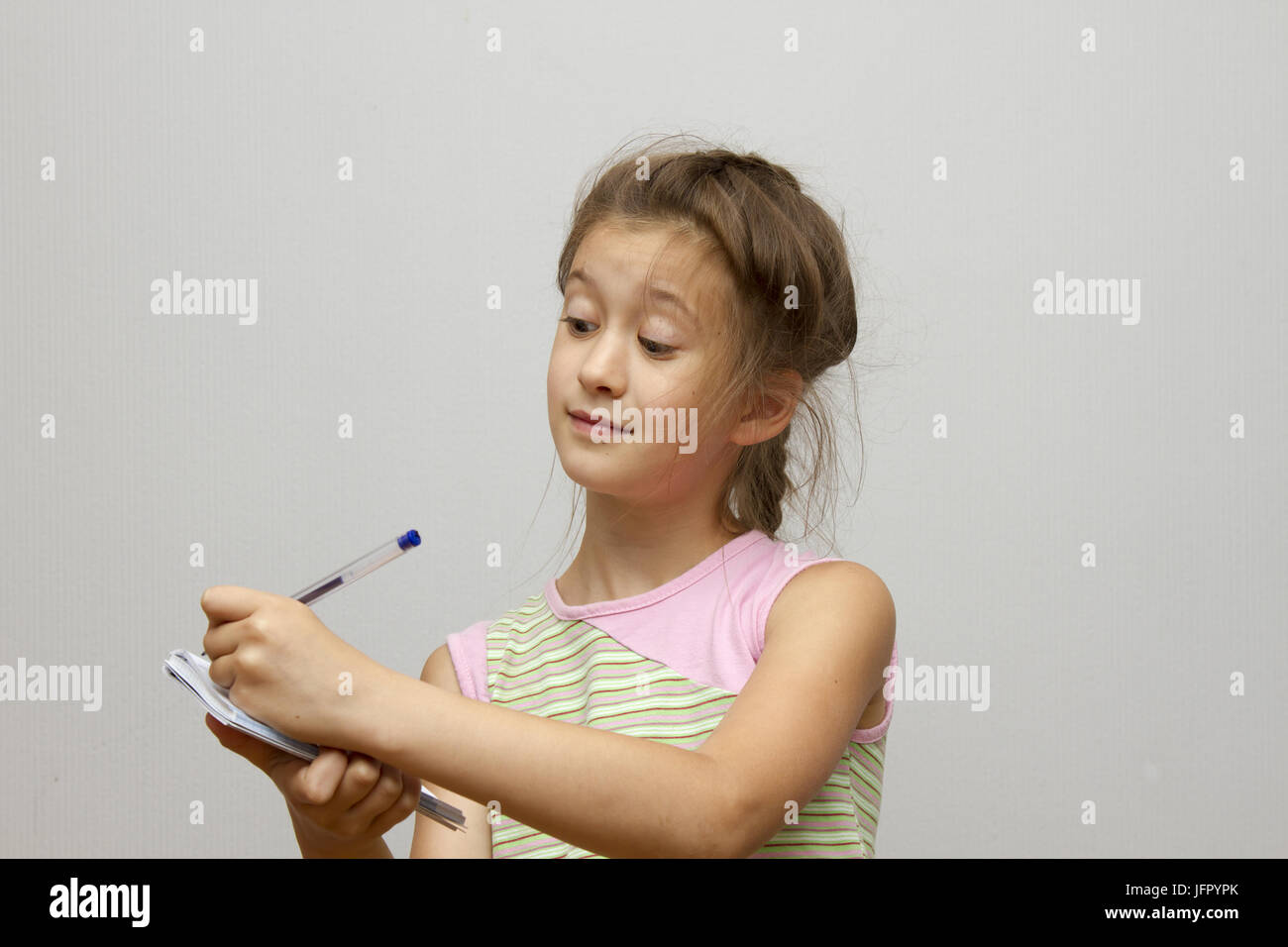 cute happy little girl writing something in her notebook Stock Photo ...