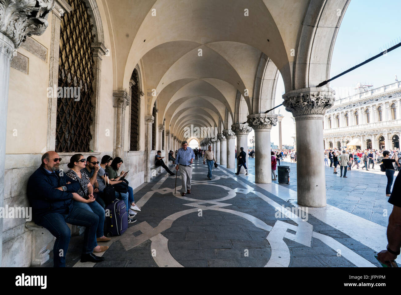 Venice, Veneto / Italy- May 21, 2017: People resting under the arches ...