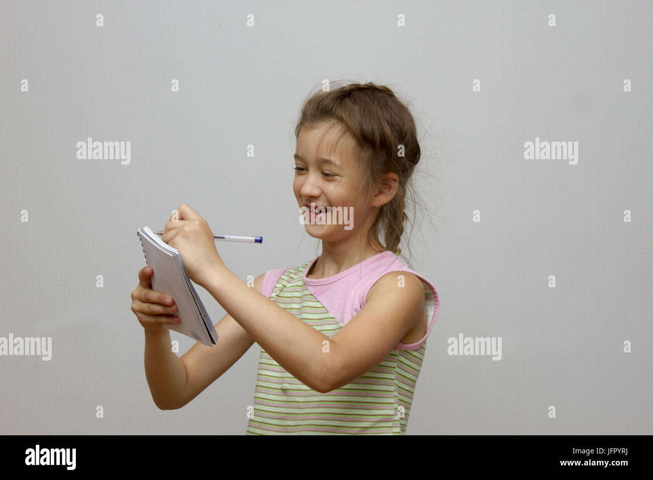 cute happy little girl writing something in her notebook Stock Photo ...