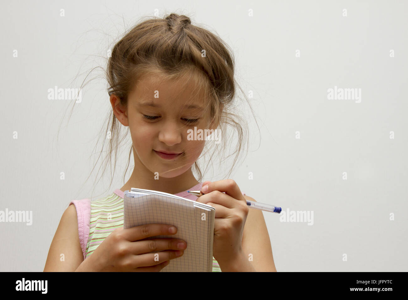 cute happy little girl writing something in her notebook Stock Photo ...