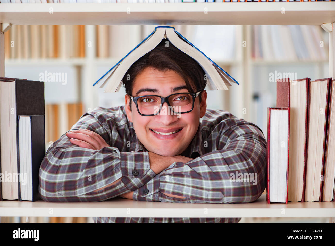 Young student looking for books in college library Stock Photo - Alamy