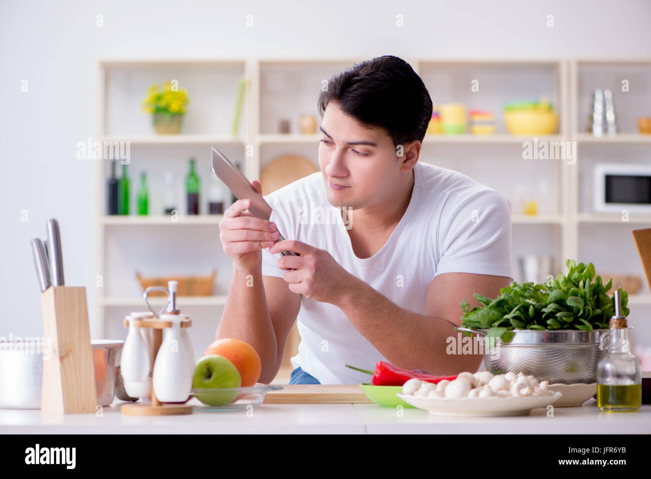 The young male cook working in the kitchen Stock Photo - Alamy