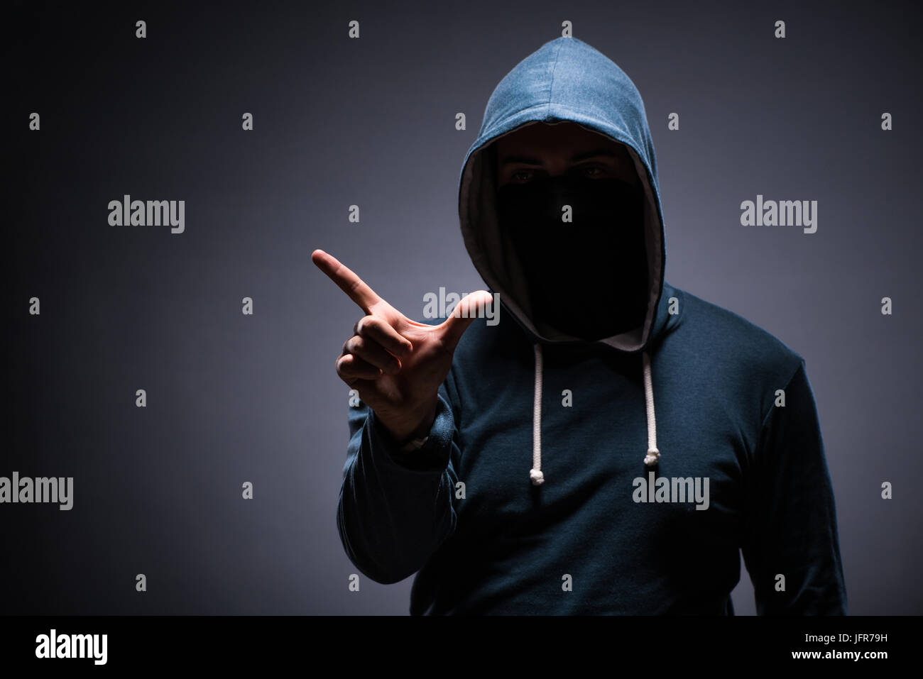 The man wearing hood in dark room Stock Photo - Alamy