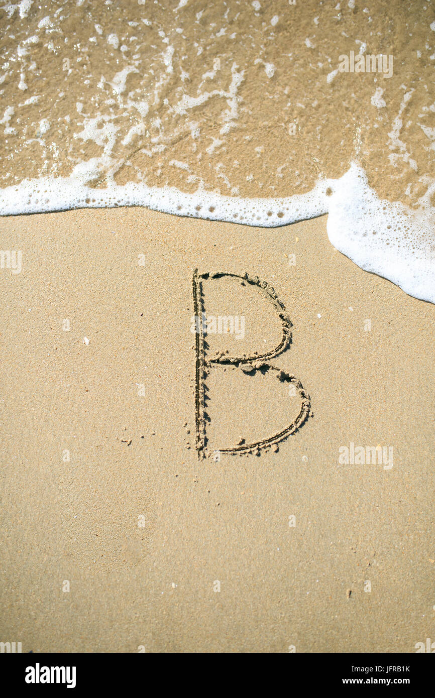Letter drawn on the sand beach Stock Photo - Alamy