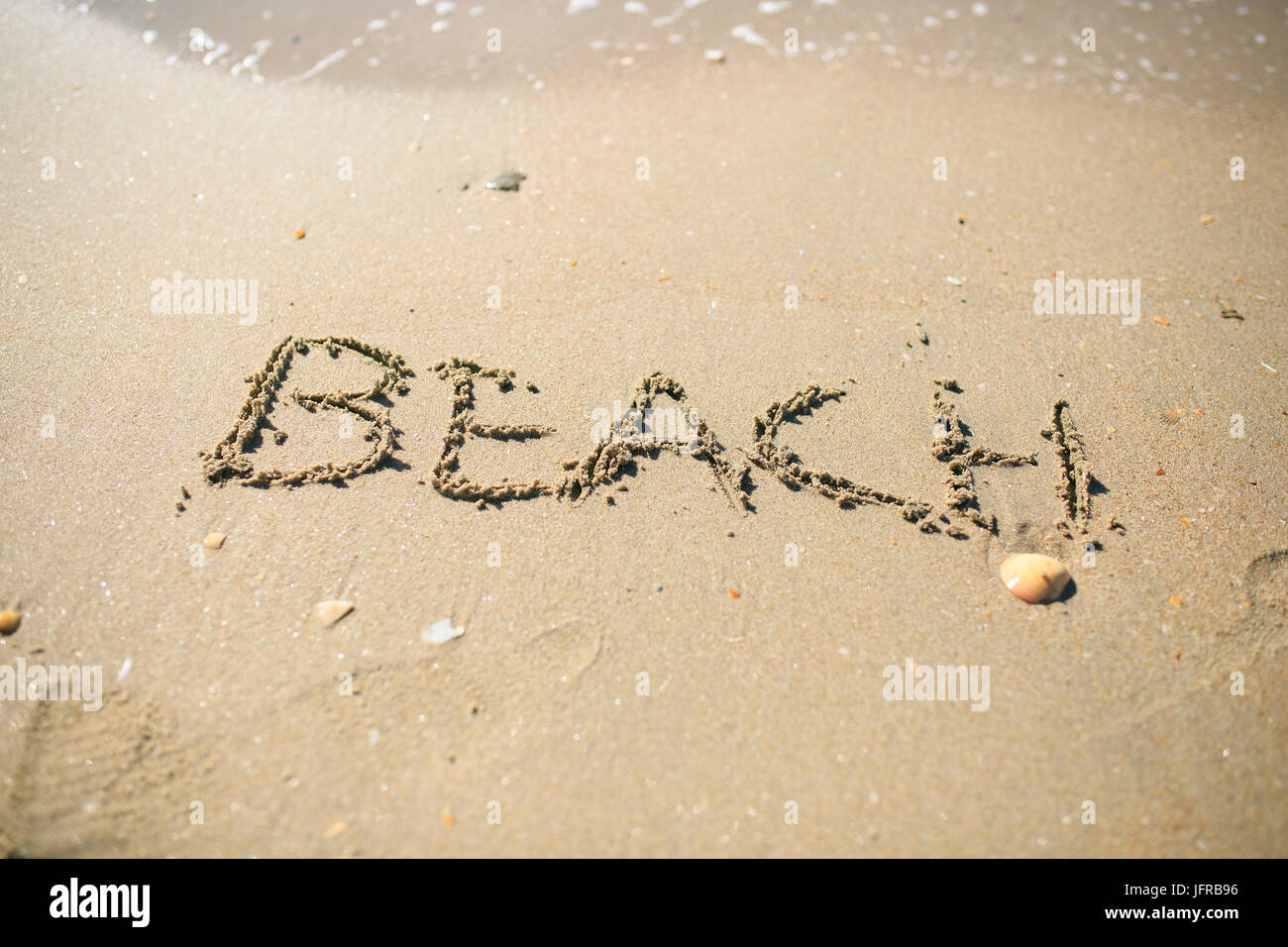 Letter drawn on the sand beach Stock Photo - Alamy