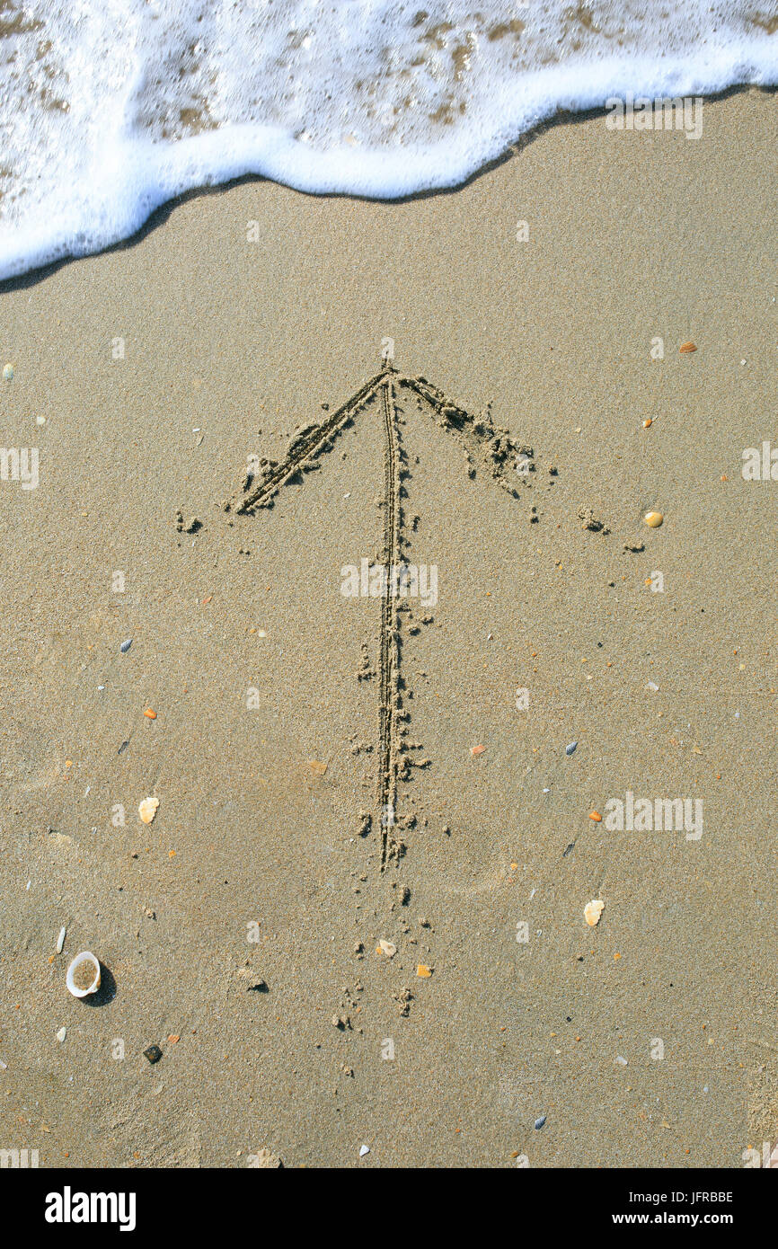 Arrow drawn on the sand beach Stock Photo - Alamy