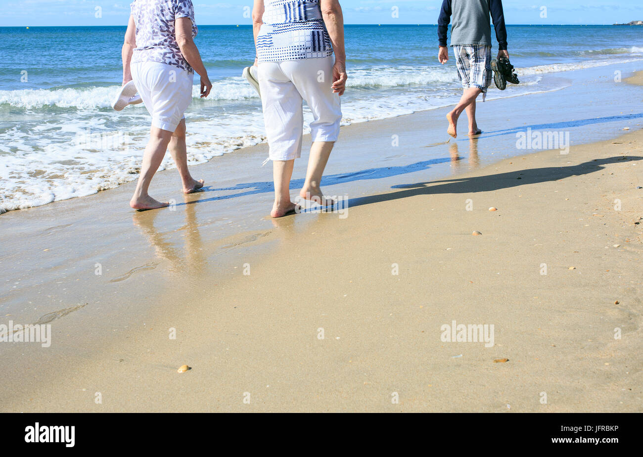 Old people taking a walk on the beach Stock Photo - Alamy