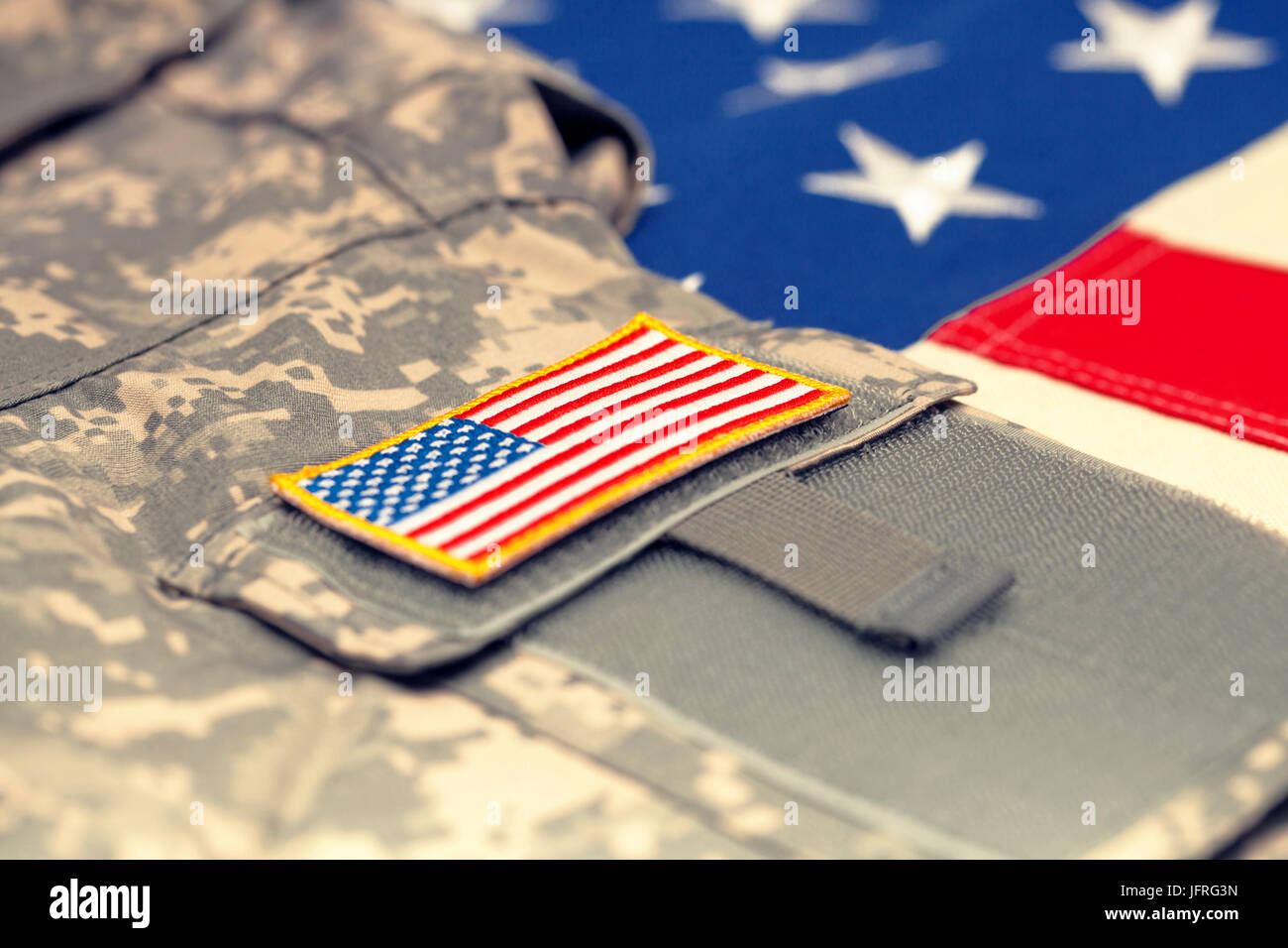 US flag with army uniform over it - studio shot. Filtered image: cross ...