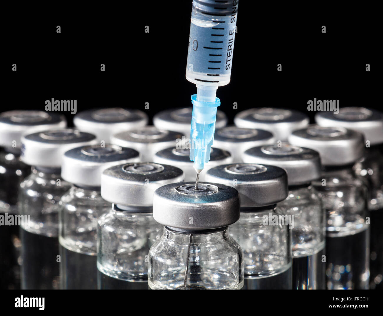 Glass Medicine Vials and Syringe on black background Stock Photo - Alamy