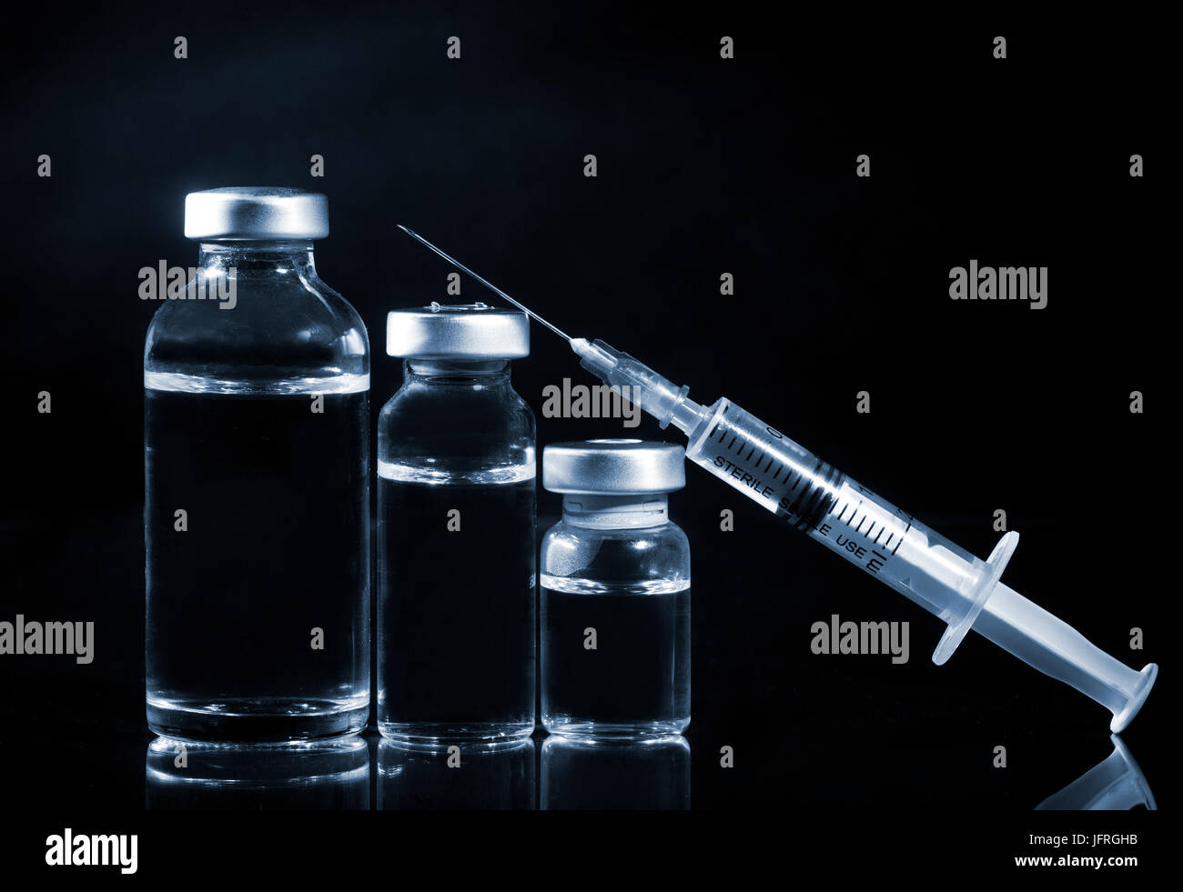 Glass Medicine Vials and Syringe on black background. TInted image ...