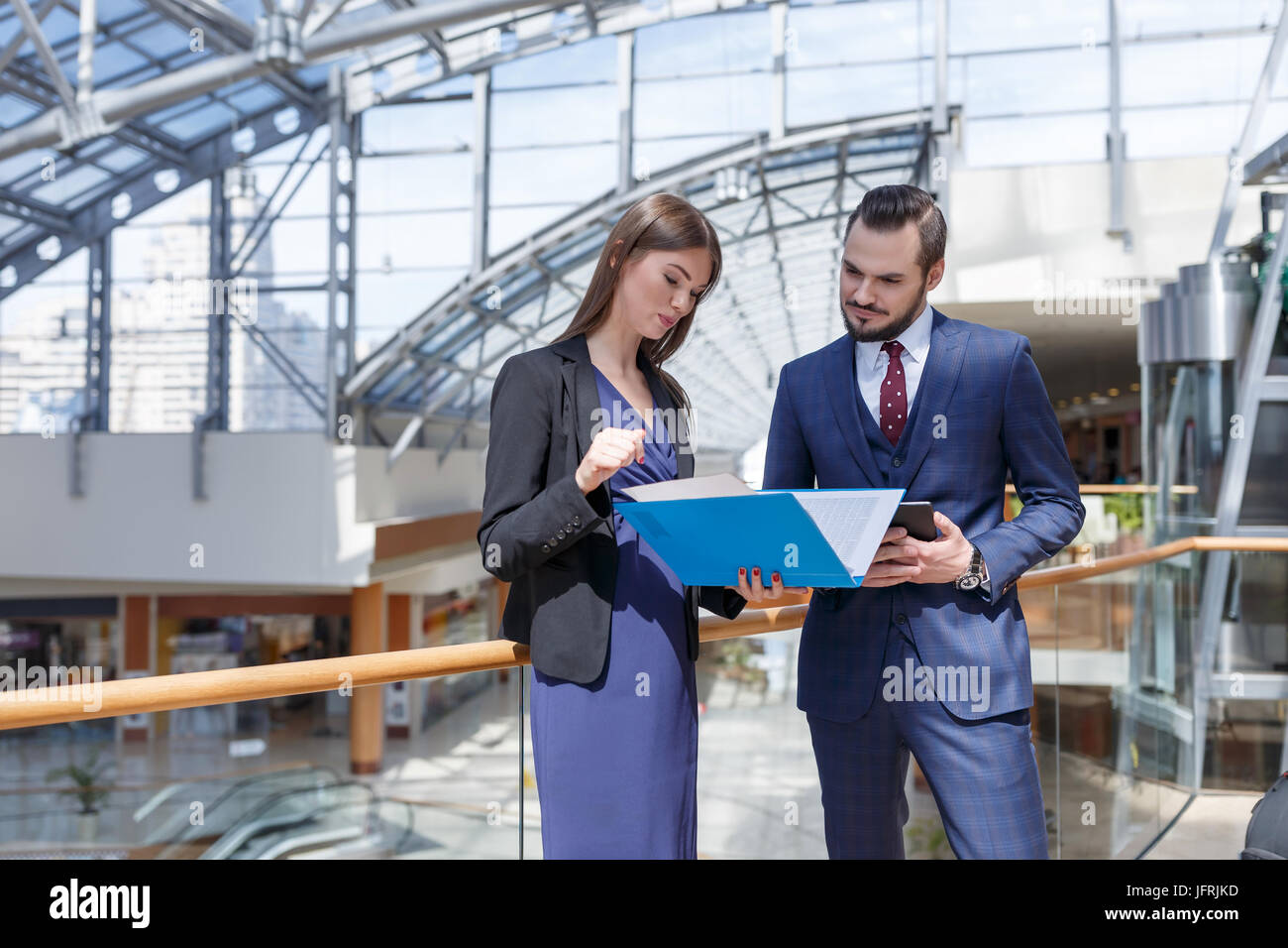 Business partners talking and looking at documents at business center ...