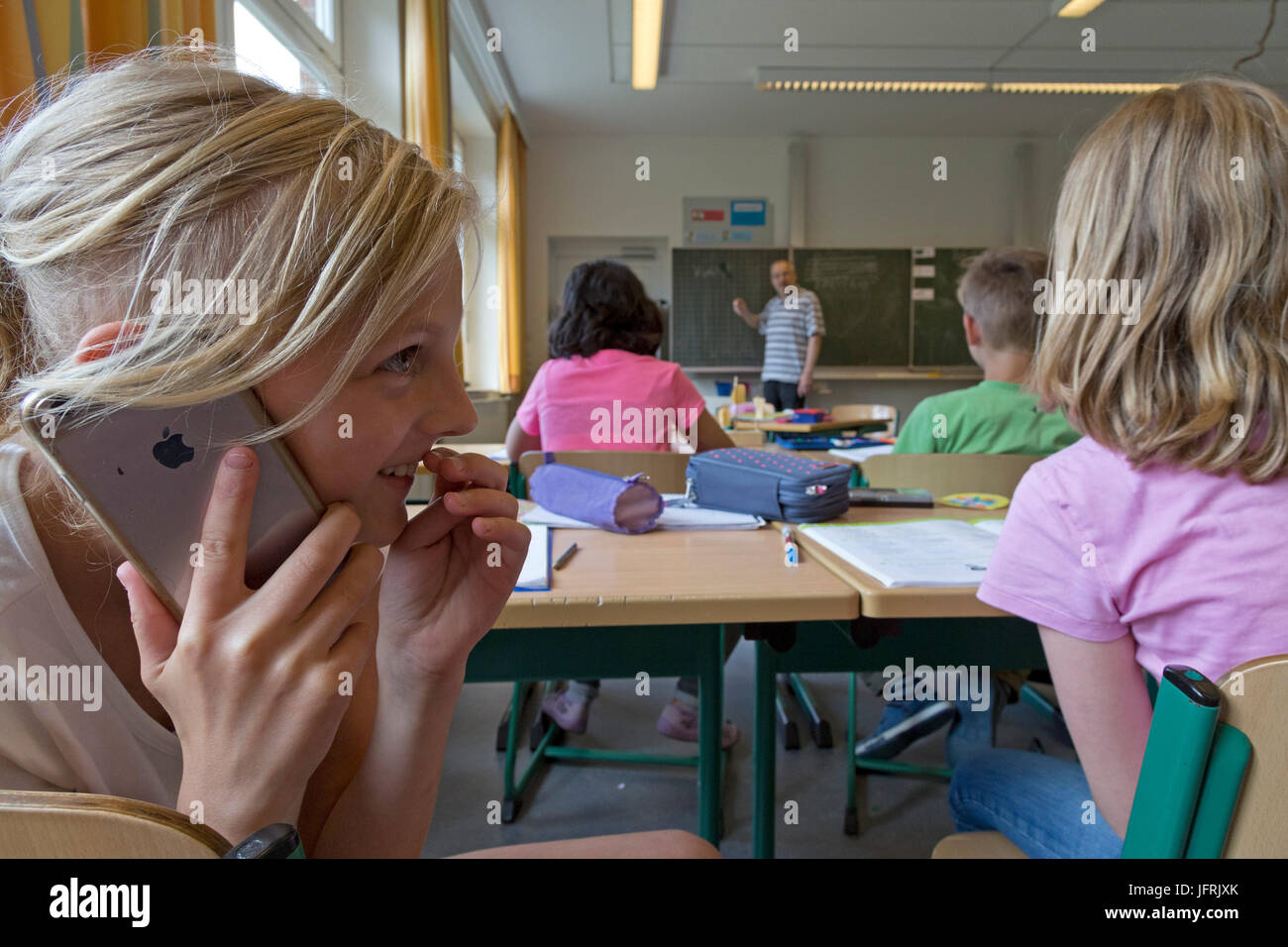 primary school girl using her mobile phone during class Stock Photo - Alamy