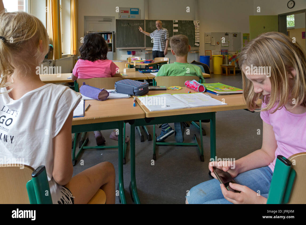 primary school girl using her mobile phone during class Stock Photo - Alamy