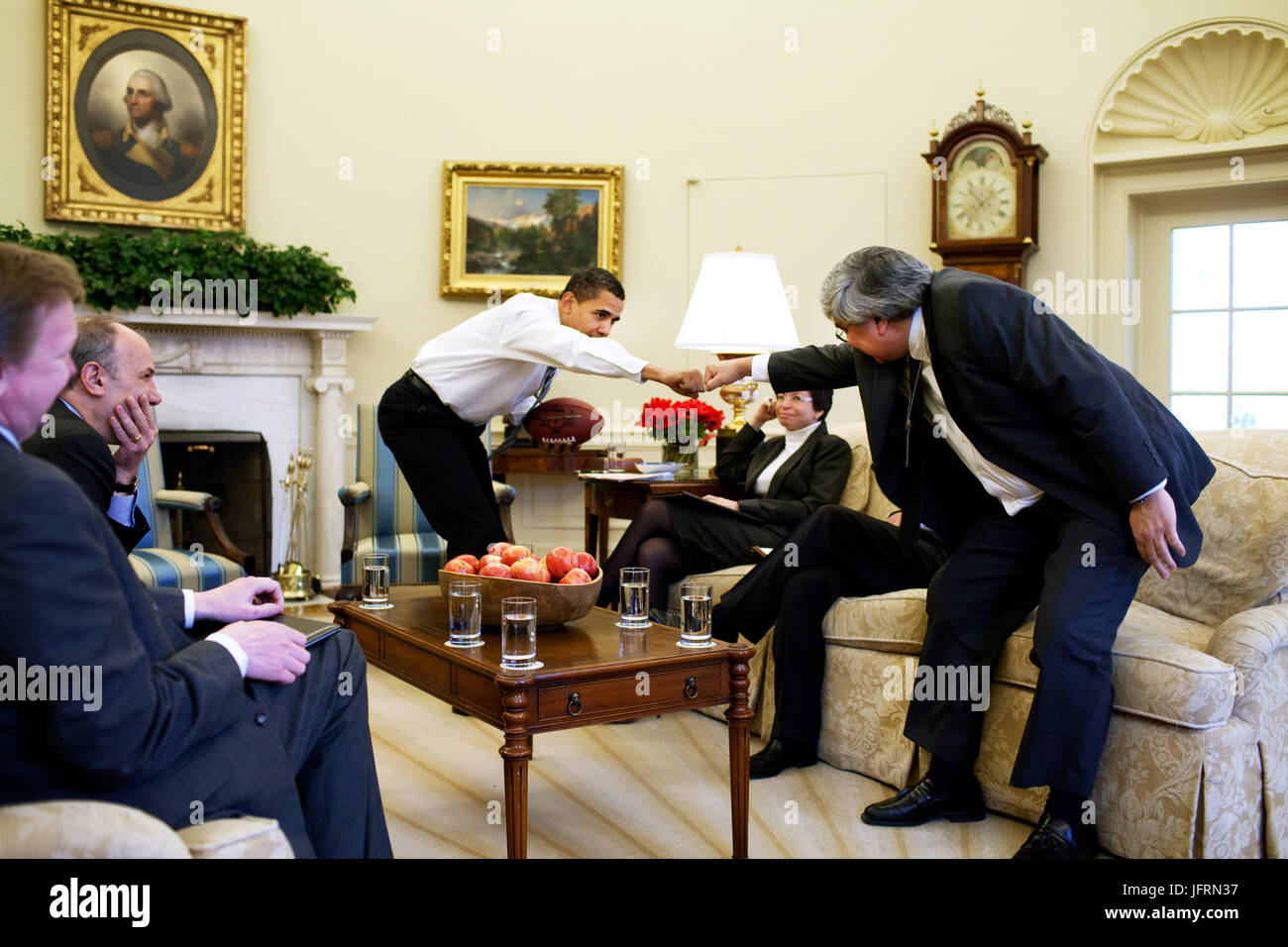 President Barack Obama, holding a football, offers a fist-bump April 8 ...