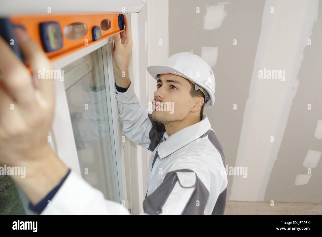 construction worker installing window in house Stock Photo - Alamy