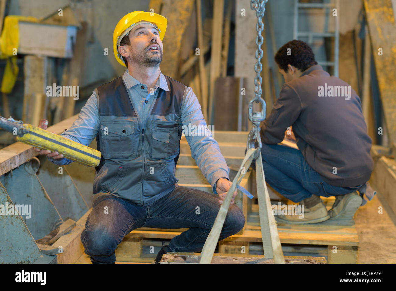 worker using an industrial hoist with the chain in factory Stock Photo ...
