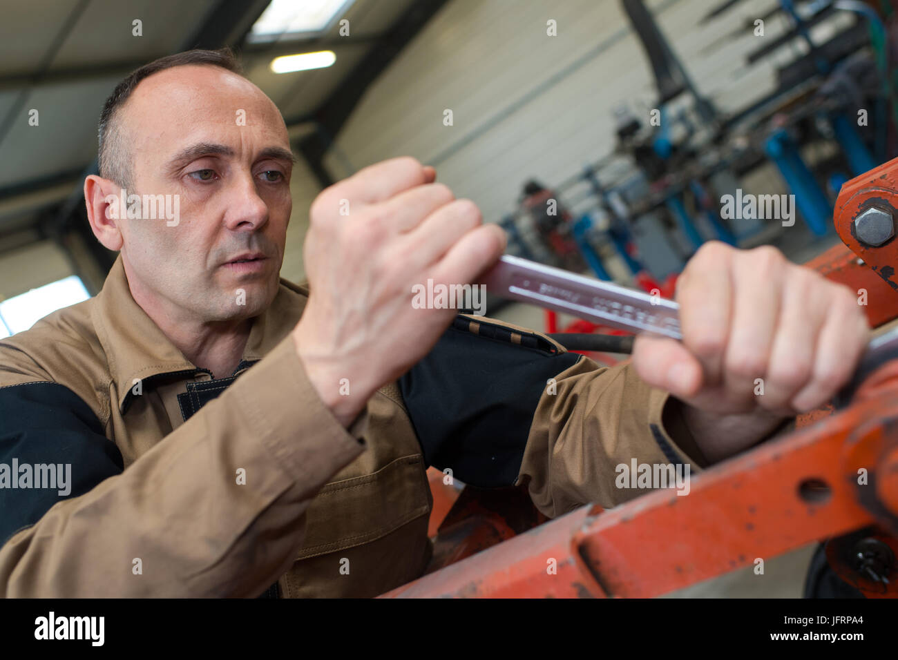 technician in factory at machine maintenance working with wrench Stock ...