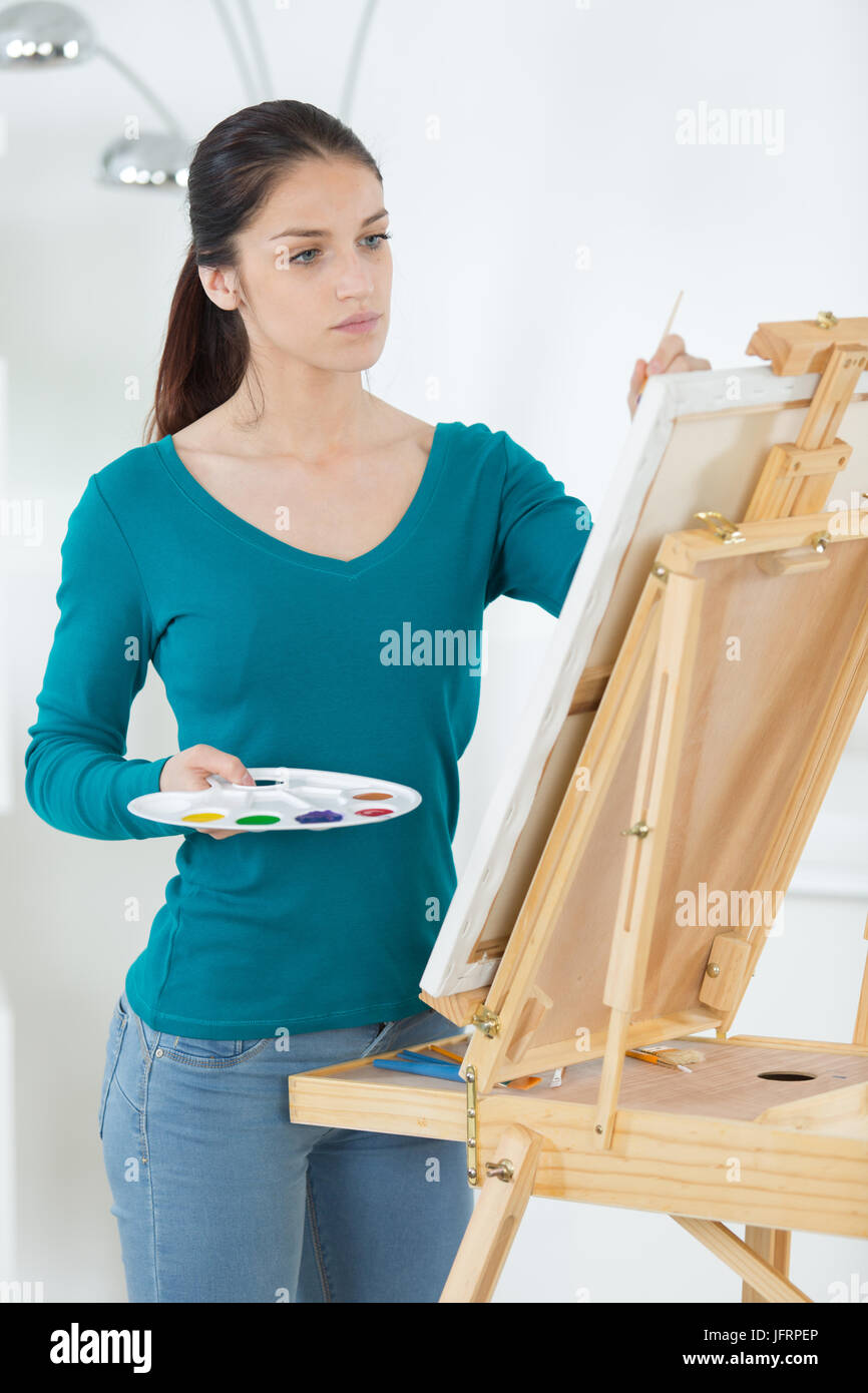 pretty artist painting on a canva Stock Photo - Alamy