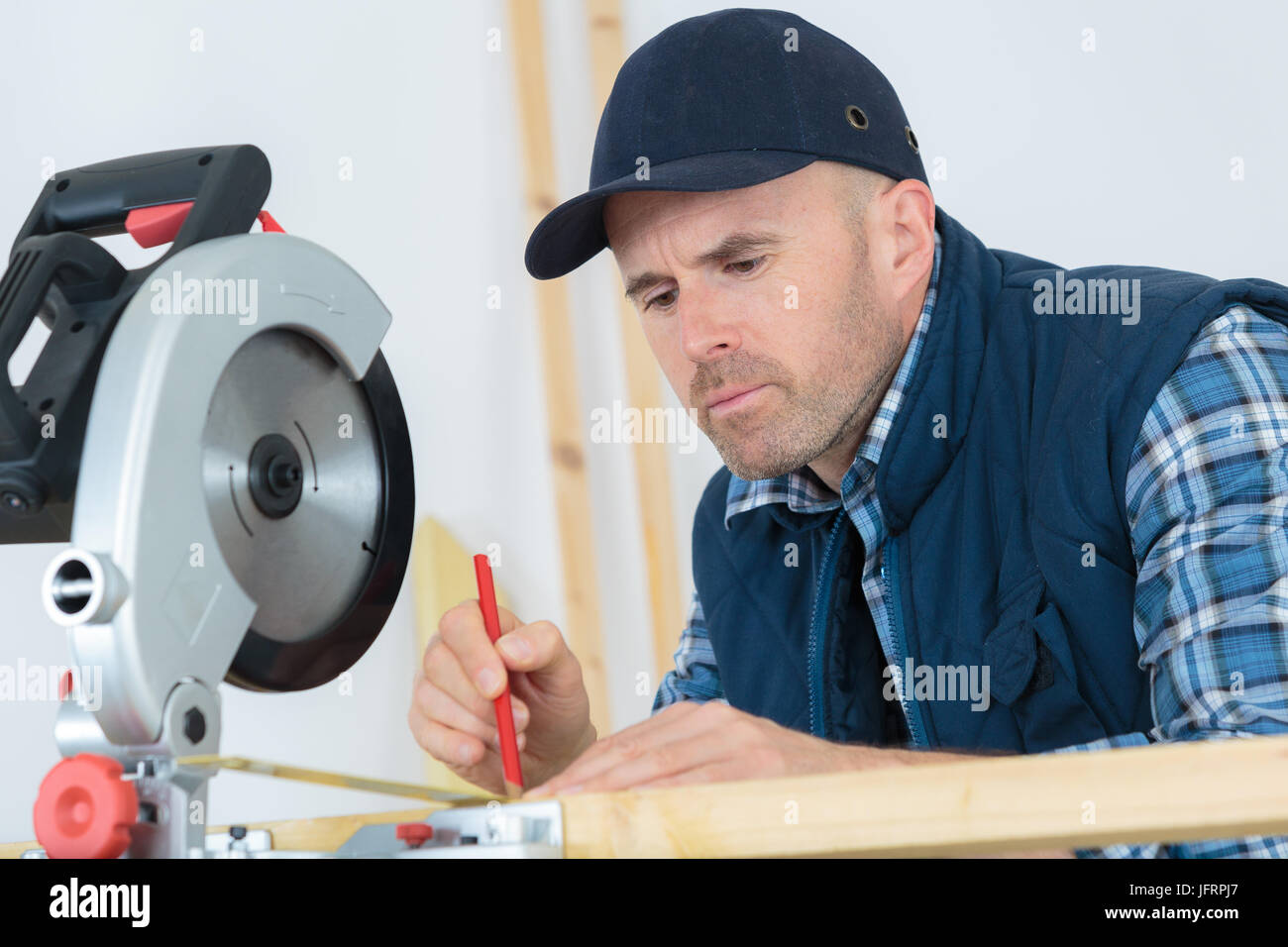 handsome carpenter measuring wood using a tape measure and pencil Stock ...