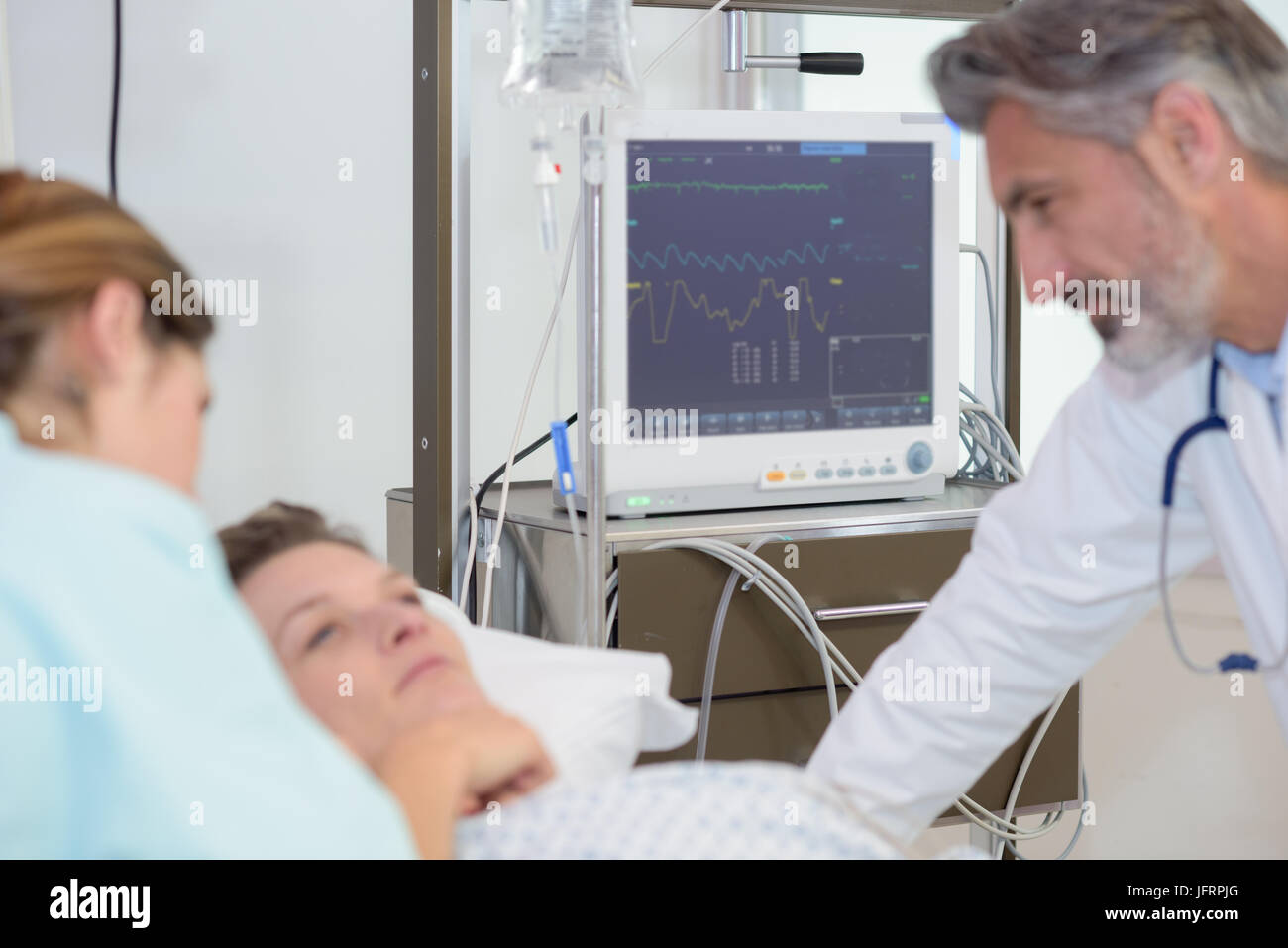 doctor and a nurse stand around a patient in hospital Stock Photo - Alamy