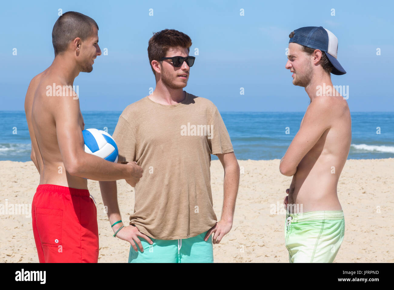 group of three attractive young men on the beach Stock Photo - Alamy