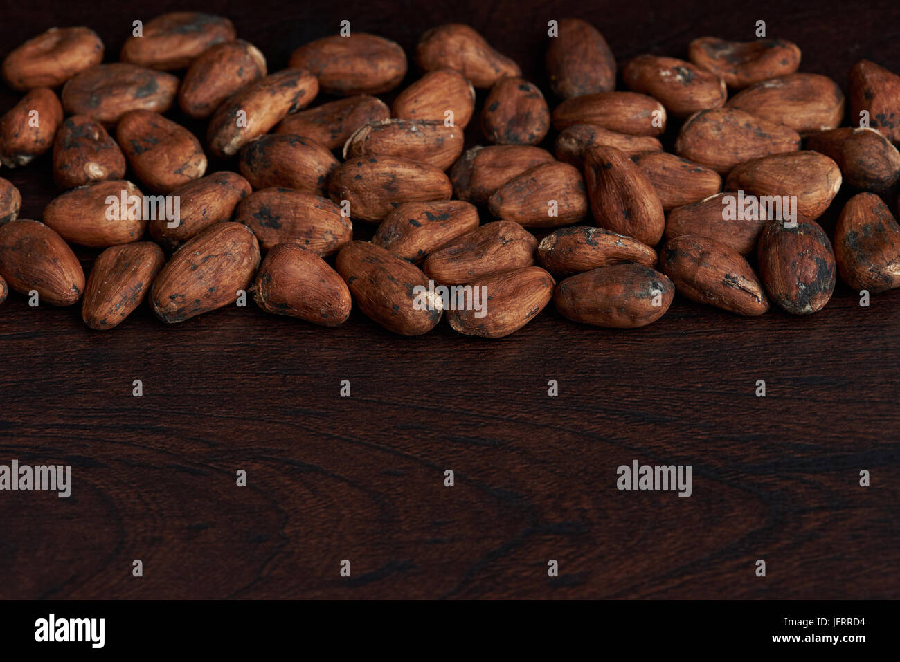 Dry cocoa seeds background. Brown cacao beans on dark wood background ...