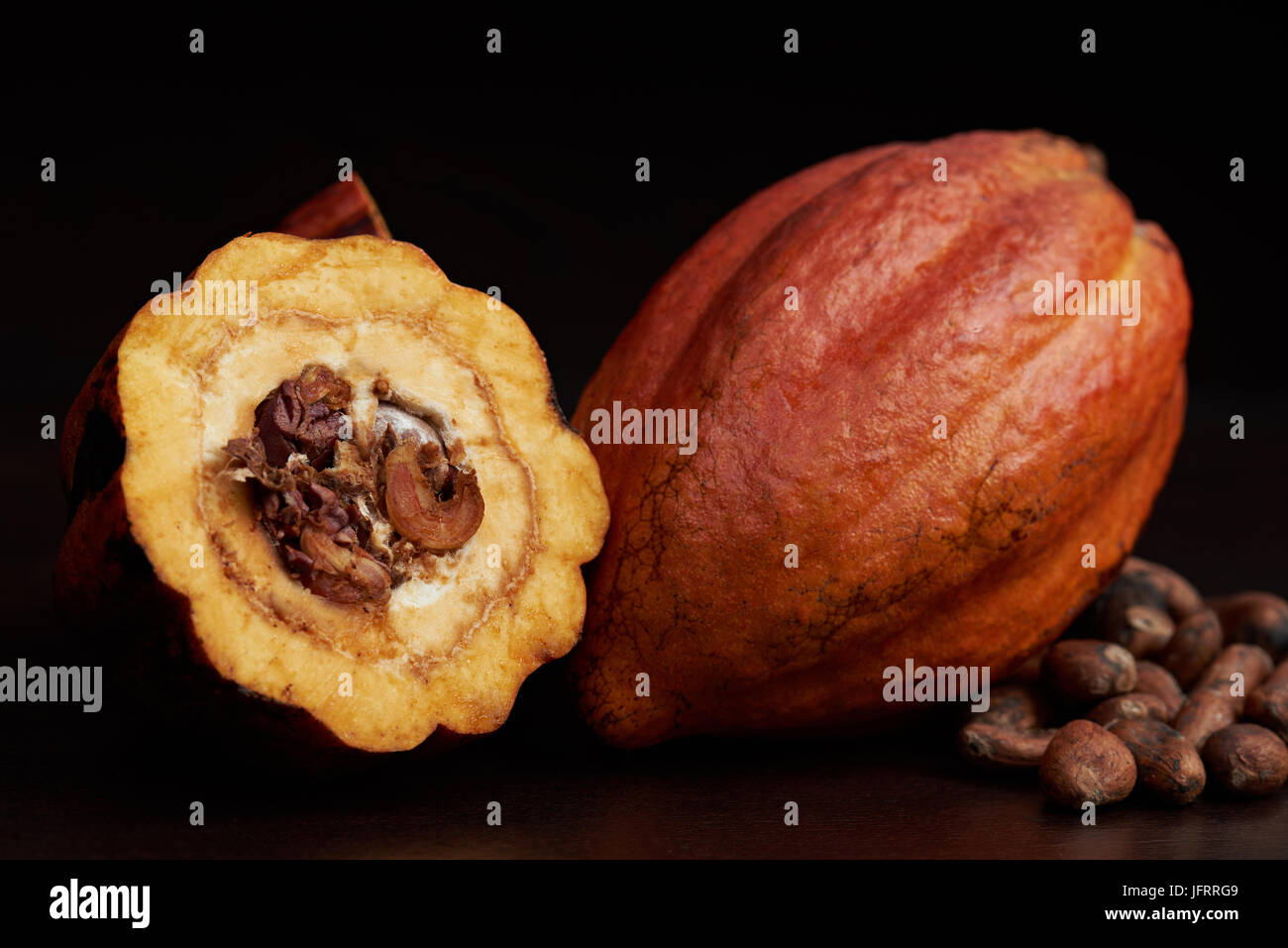 Open cocoa pod laying on dark wooden background Stock Photo - Alamy