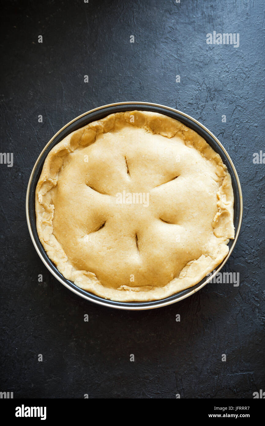 Cooking pie. Unbaked shortcrust pie (dough, filling) in baking dish ...