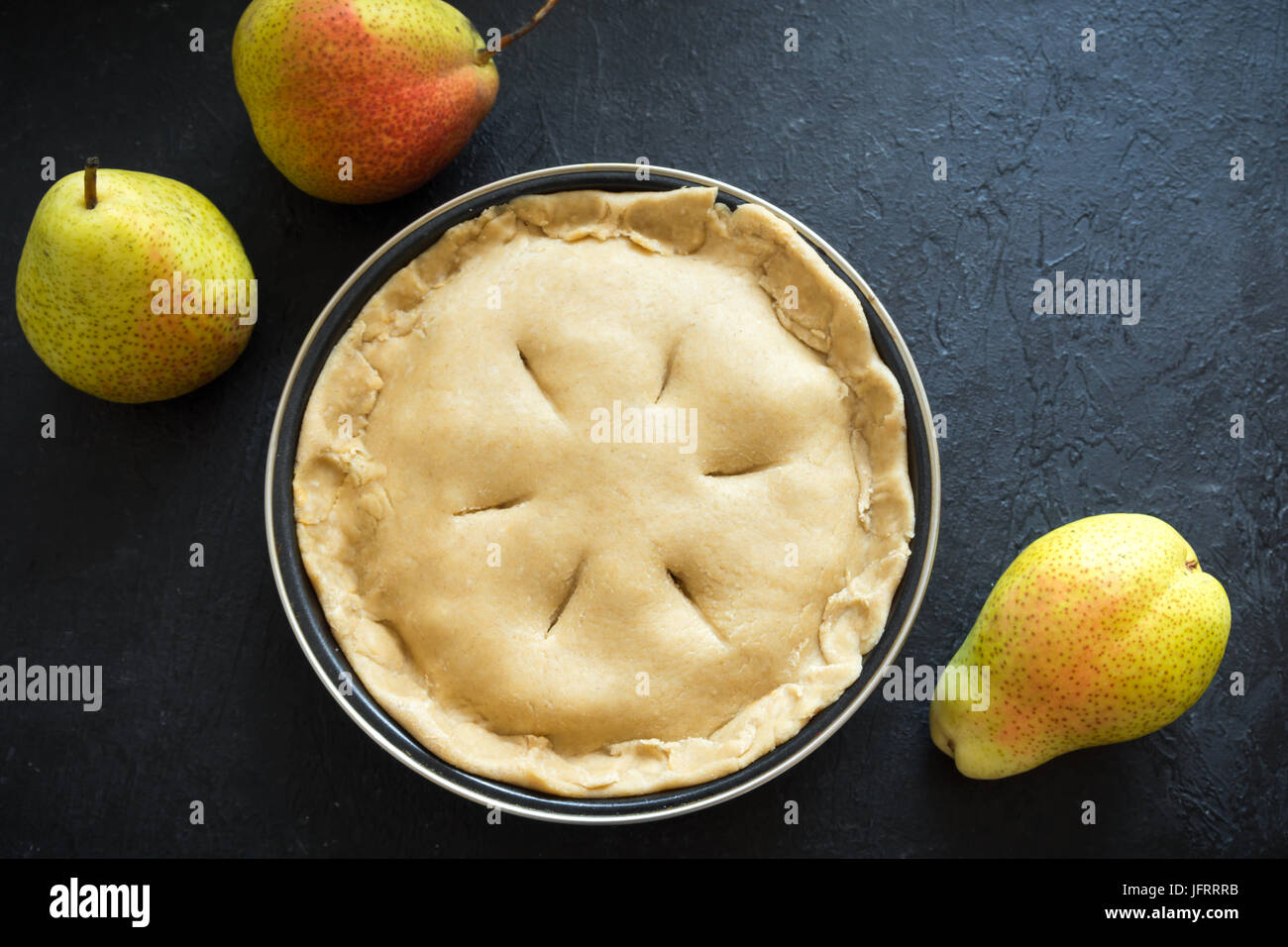 Cooking pear pie. Unbaked shortcrust pie (dough, filling) in baking ...