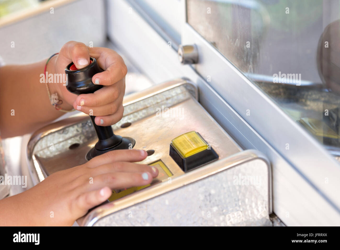 A kid pressing button on joystick. Horizontal outdoors shot Stock Photo ...