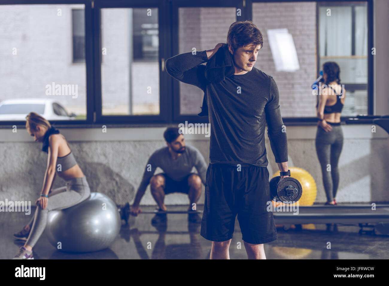 athletic tired sportsman with dumbbell at the gym, gym workout concept ...