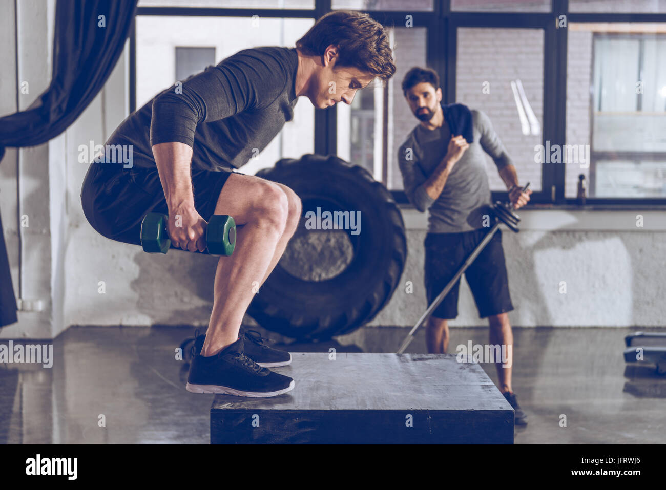 Muscular young men in sportswear exercising at gym workout Stock Photo ...