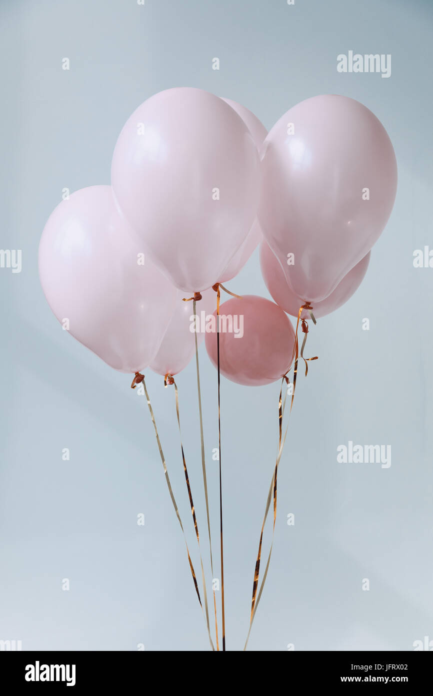 pink air balloons with golden ribbons isolated on grey Stock Photo - Alamy