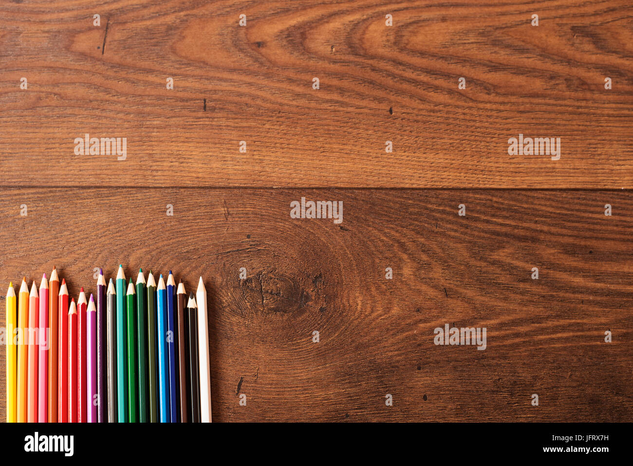 Colorful pencils on the brown wooden table background. Frame of colored ...