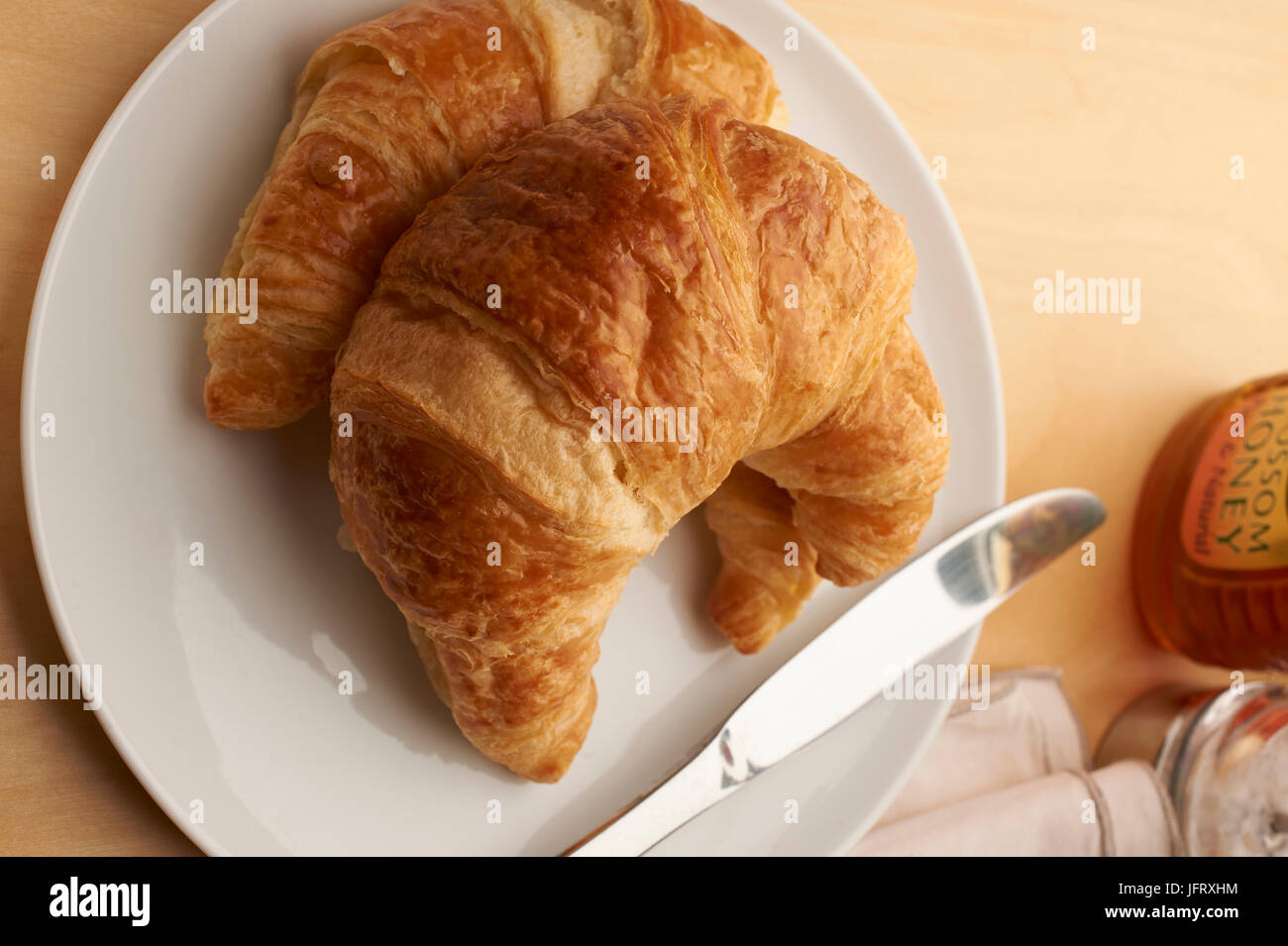 A breakfast table with croissant and honey Stock Photo - Alamy