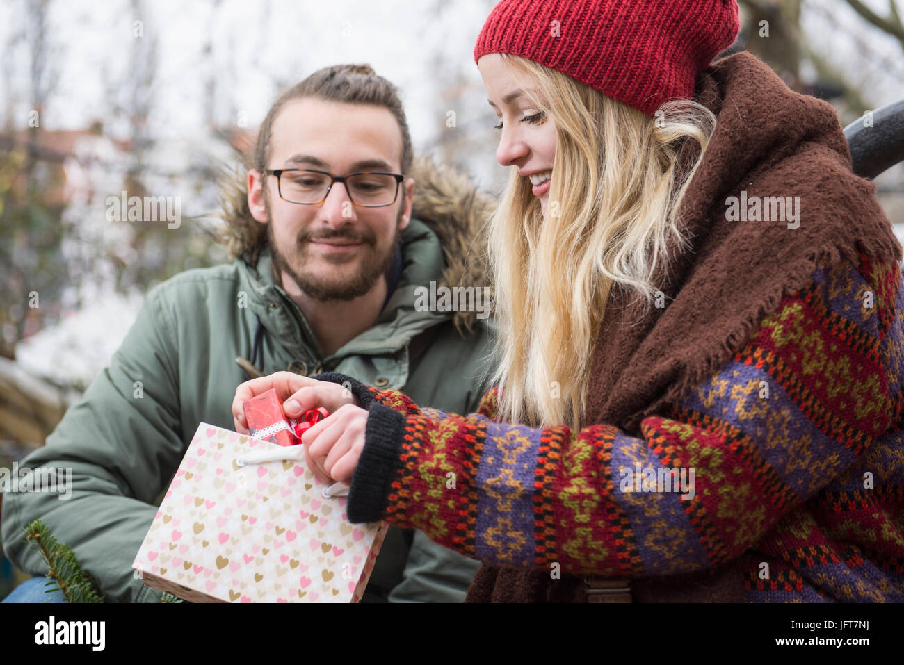Young woman taking gift from bag Stock Photo - Alamy