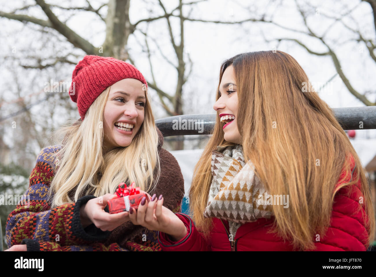 Young woman giving gift to her friend Stock Photo - Alamy