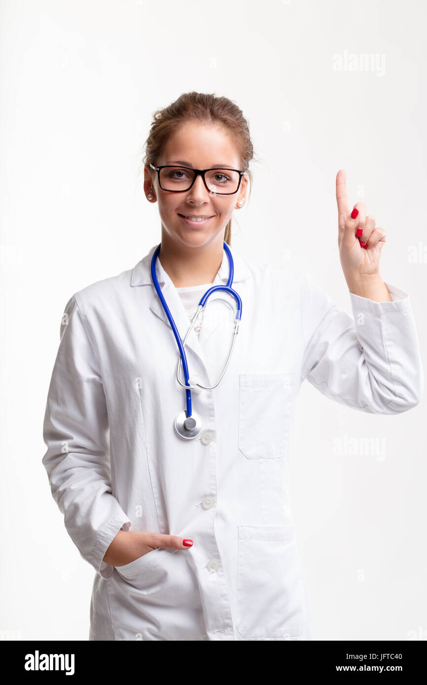 Relaxed smiling doctor pointing above her head with her index finger ...