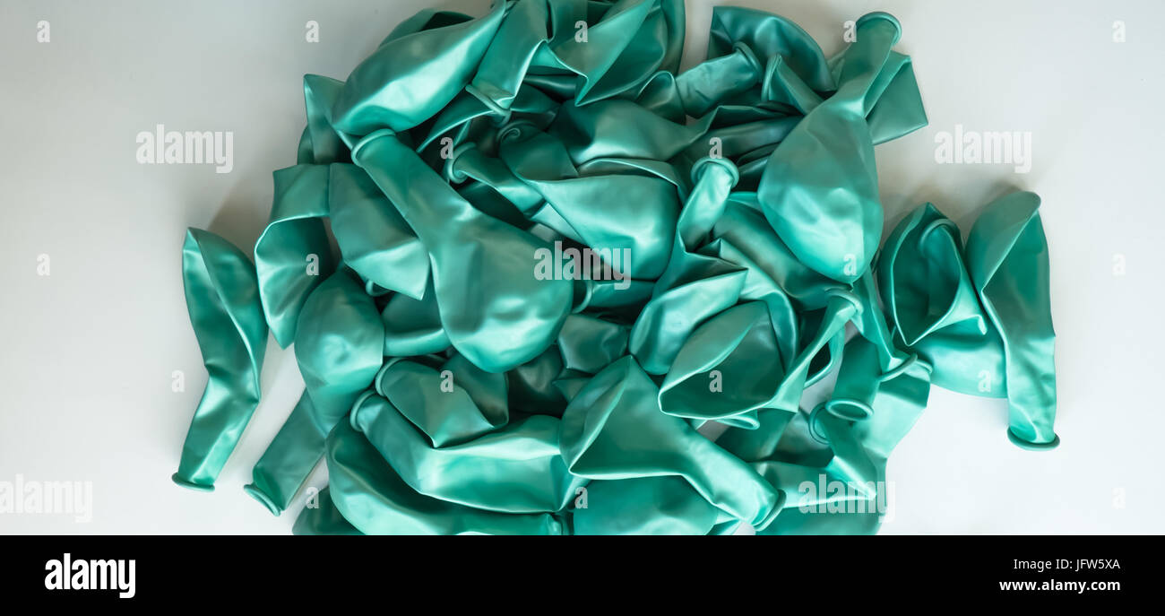 Deflated green rubber air balloon isolated over the white background ...