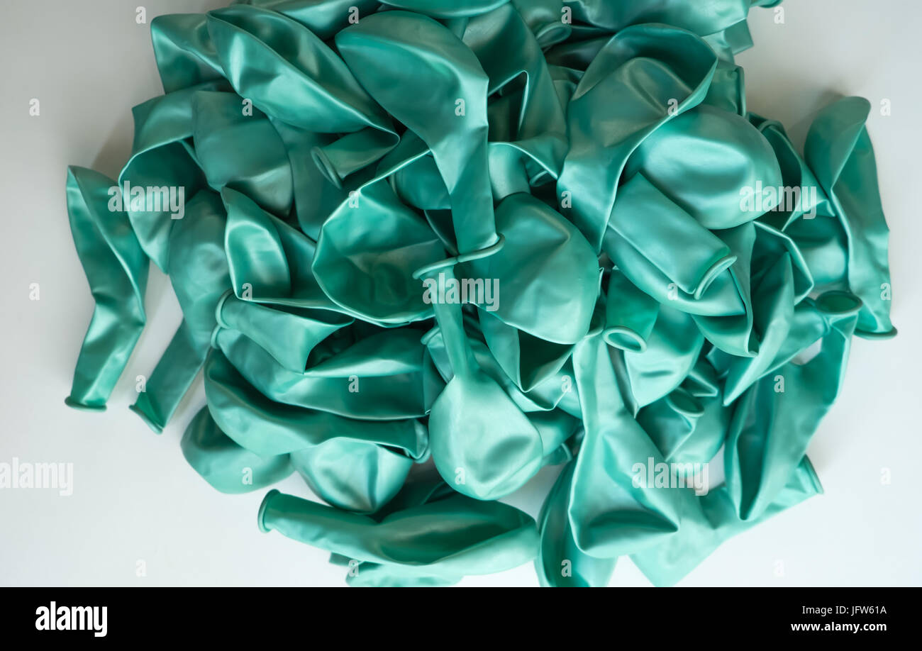 Deflated green rubber air balloon isolated over the white background ...