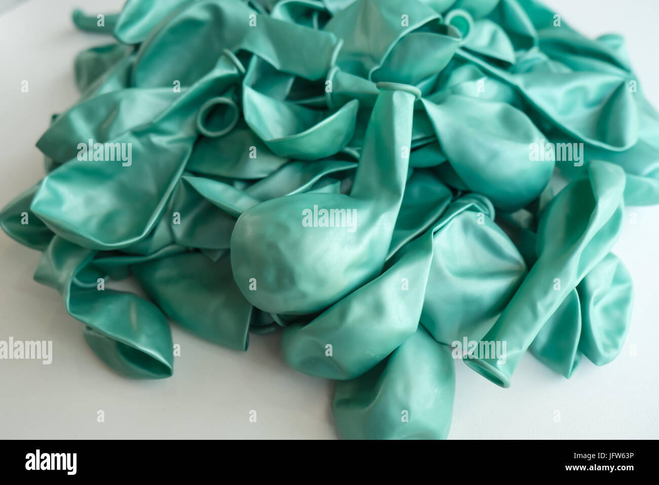 Deflated green rubber air balloon isolated over the white background ...