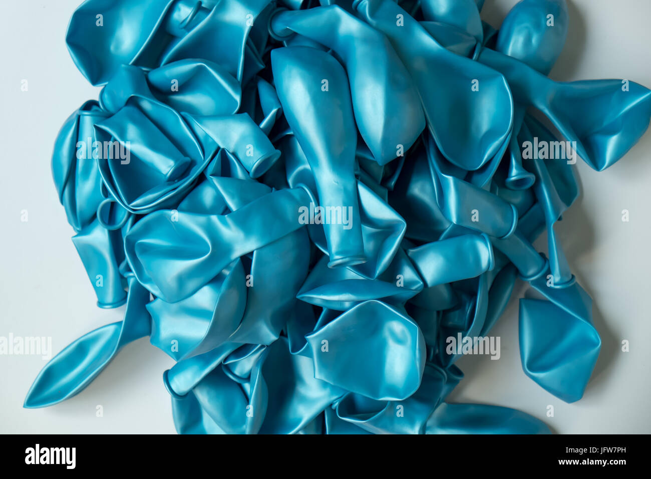 Deflated blue rubber air balloon isolated over the white background ...