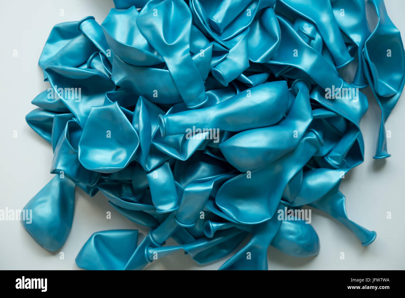 Deflated blue rubber air balloon isolated over the white background ...