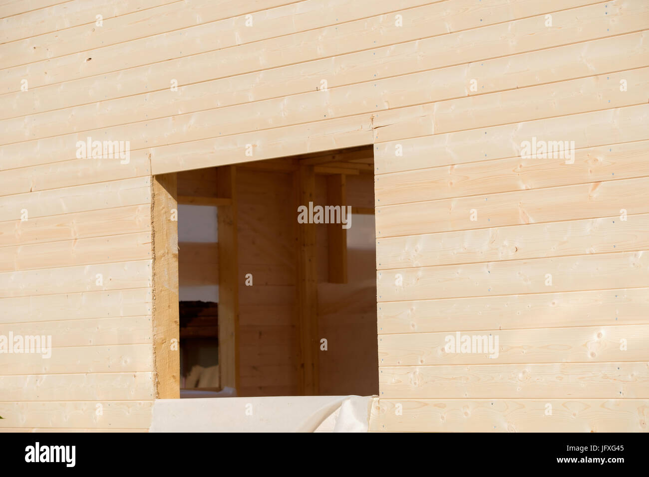 The window opening in the wall of a new wooden house under construction ...
