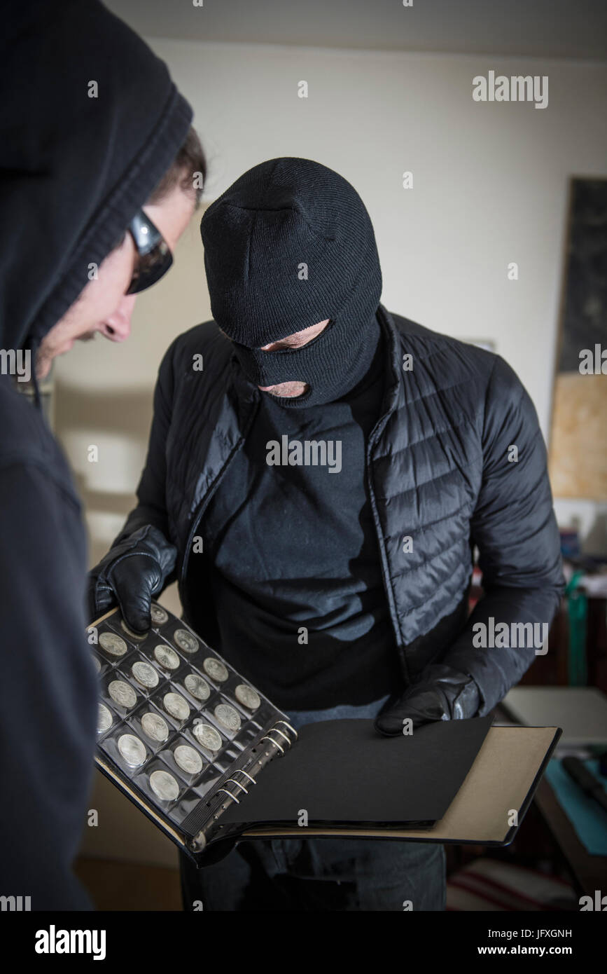 Burglars stealing a coin album Stock Photo - Alamy